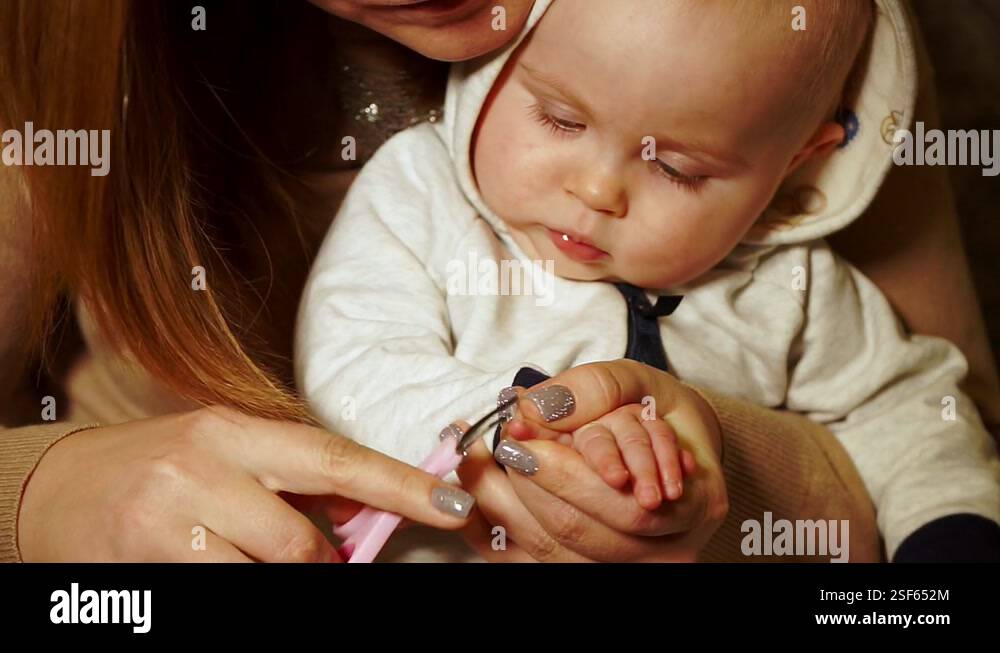Mother trims her daughter fingernails. Child is watching closely Stock ...