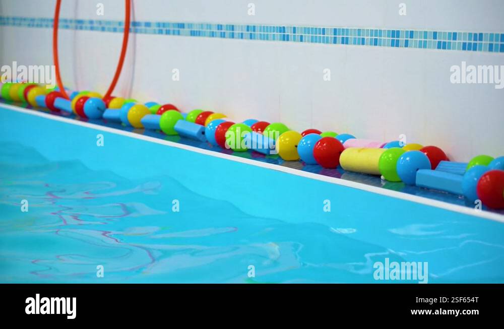 Colorful items for training in the swimming pool lie on the side near ...
