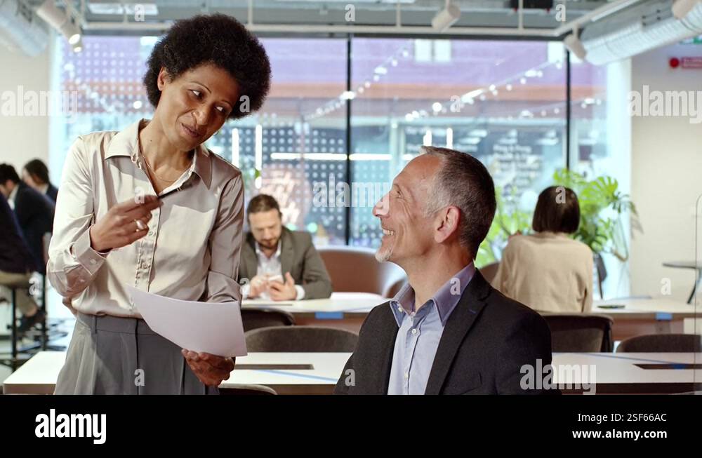 Senior businessman advising female colleague holding papers Stock Video ...