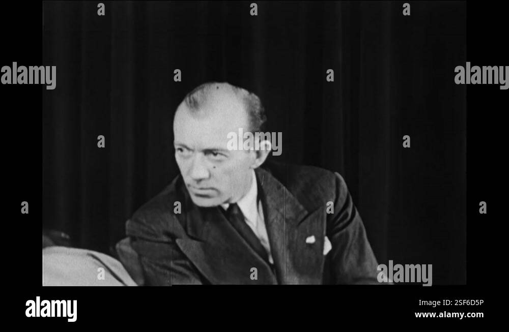 1940s: Auditorium. Men sit. Military officials brief reporters ...