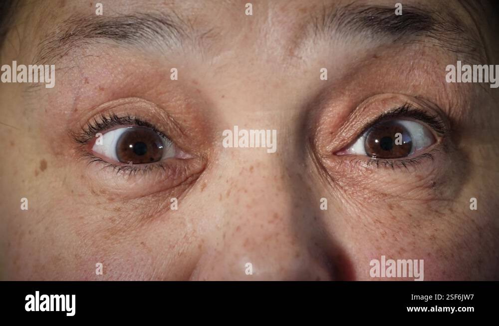 Face of surprised or shocked old Arab woman with brown eyes raising ...