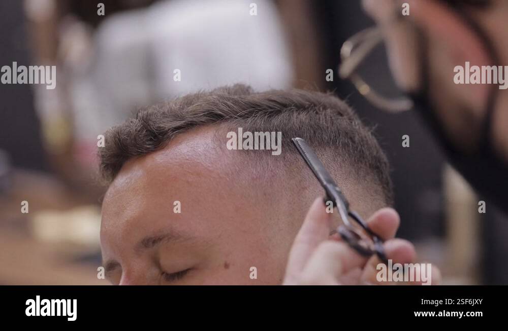 Barber haircut hair using scissors, barber makes haircut for groom ...
