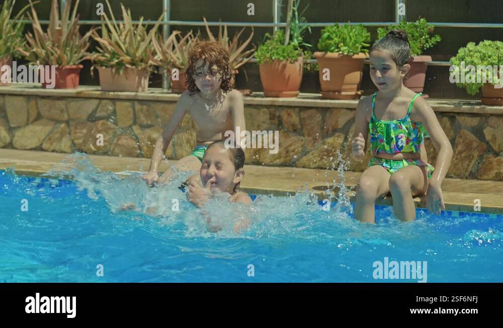 A group of boys and girls shake their feet in the pool, causing ...