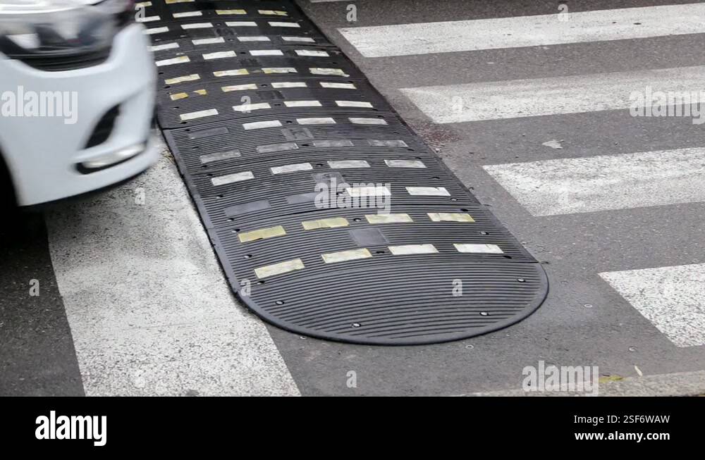 Cars on a speed bump before crosswalk. Wheels of the vehicles Stock ...