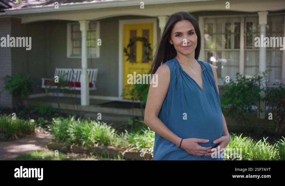 Ms Portrait Of Pregnant Woman Rubbing Her Belly In Front Of Her Home