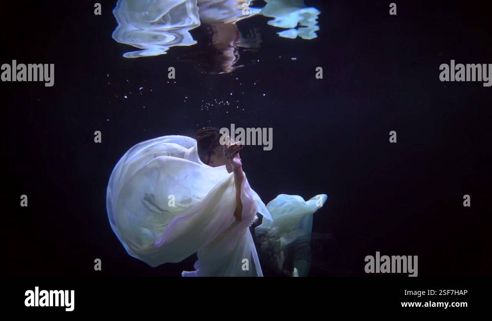 feminine graceful lady is floating underwater, enigmatic figure of ...