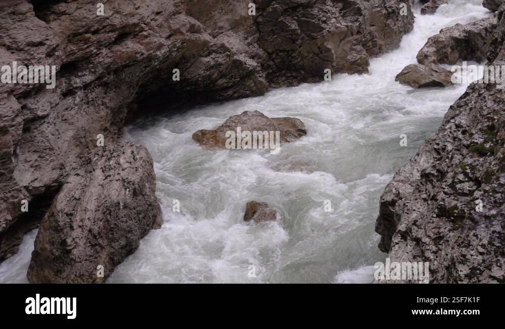 Rapid bubbling flow of a mountain river in a rocky gorge. Slow motion ...