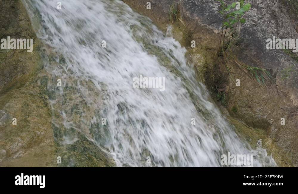 Steady stream of water cascading down a rock as part of a bigger ...