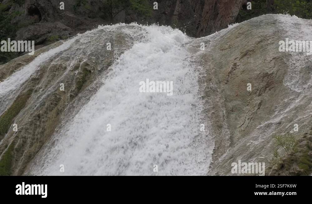 Water flowing down the edge of the rocky cliff at the top of a ...