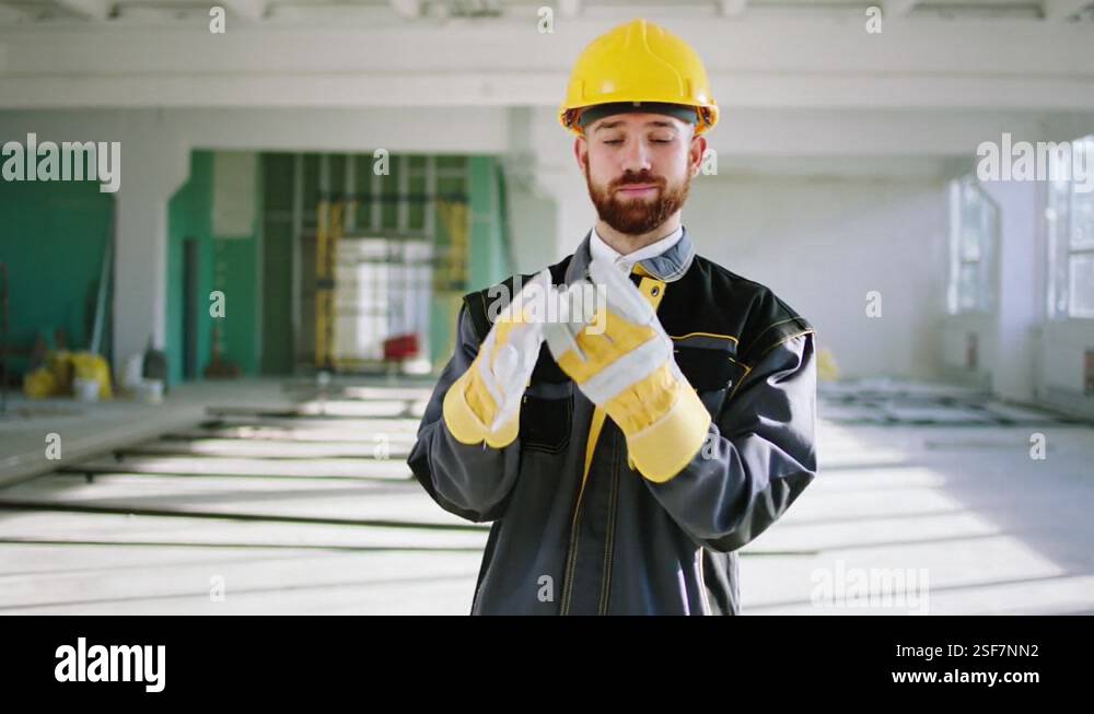 Good looking guy construction worker wearing his protective gloves in ...