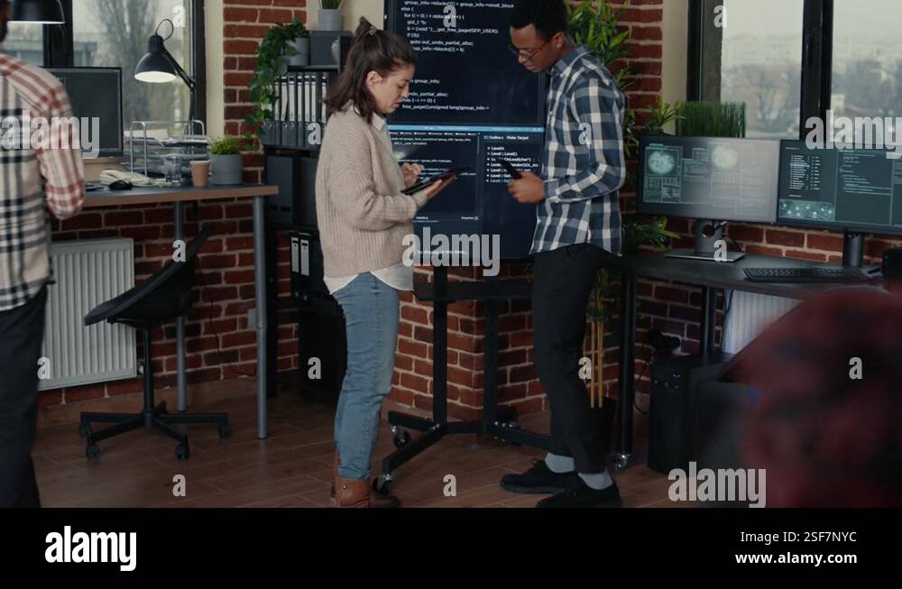 Team of database admins analyzing source code on wall screen tv comparing errors Stock Video ...