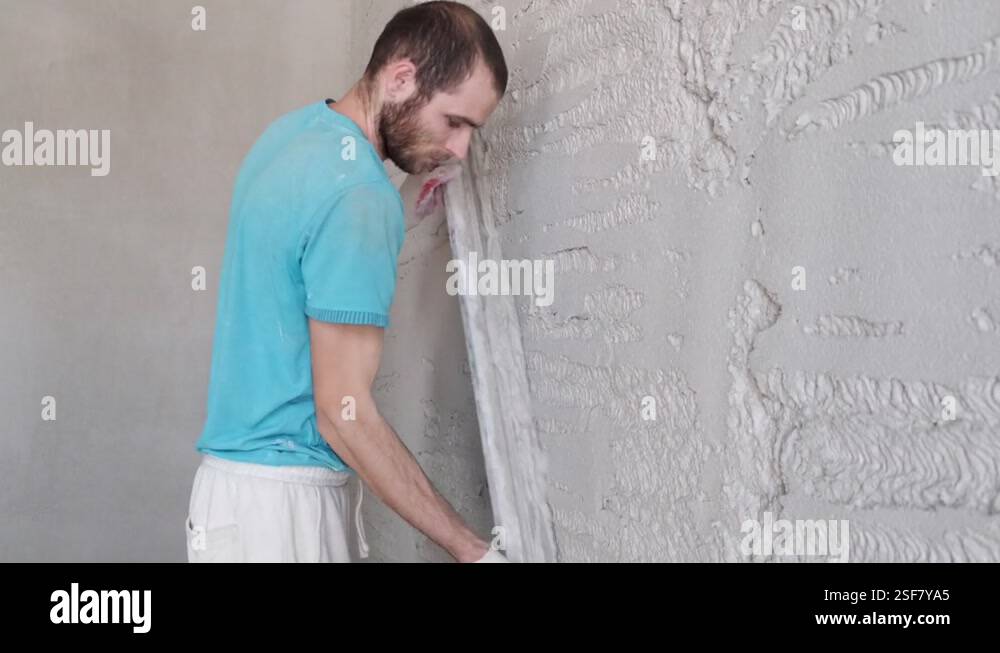 Bearded Male Plasterer Levels Thick Layer Of Plaster On Wall ...