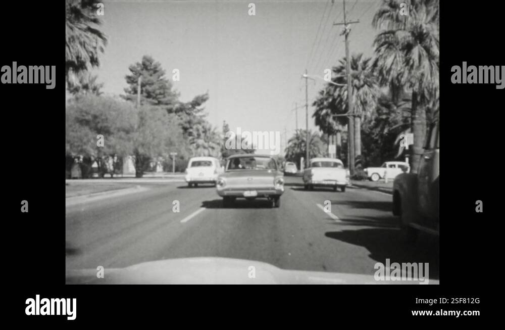 1950s: Tracking shot, cars driving down street, shape appears in ...
