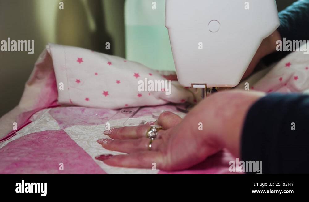 Woman machine quilting a blanket using a pattern template shaped like a ...
