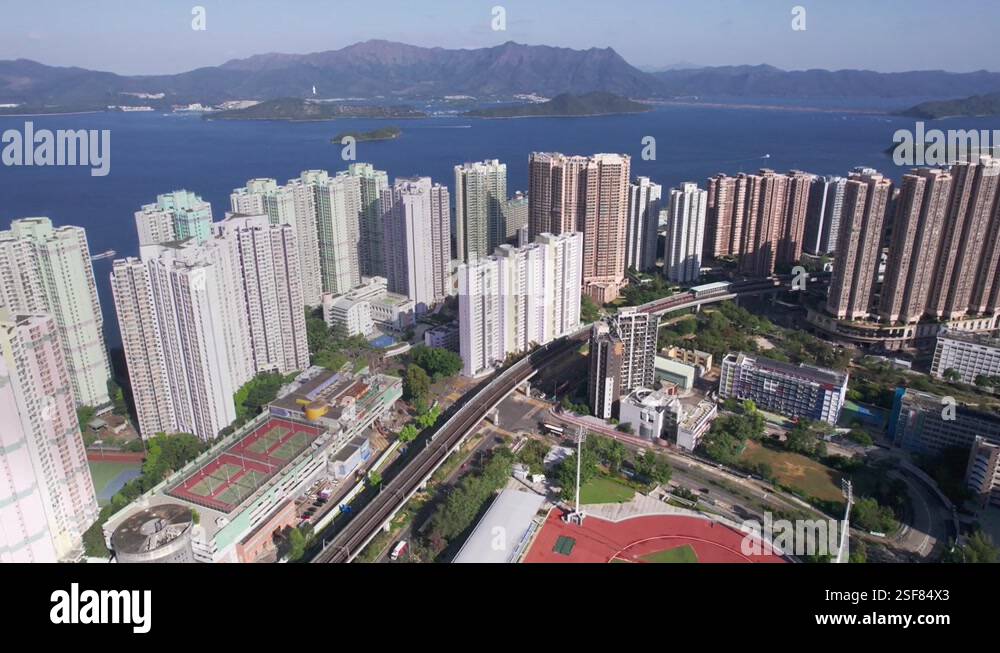 Football field and running track between the high populated skyscrapers ...