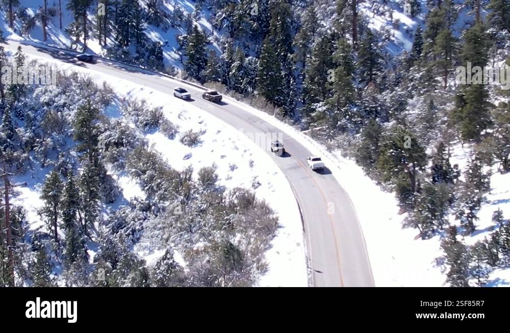 Slippery, snowing mountain road with two-way traffic traveling along ...
