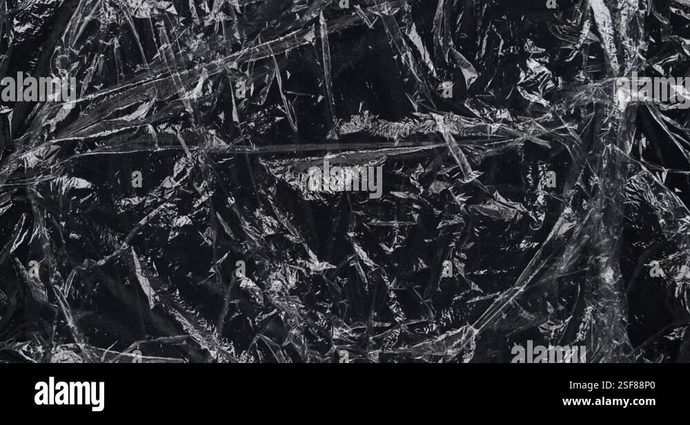 Rotation of wrinkled, crumpled packaging film. Black background made of ...