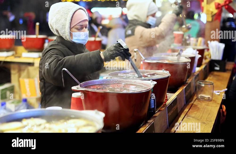 They sell and pour hot mulled wine to people in a cauldron at the fair ...