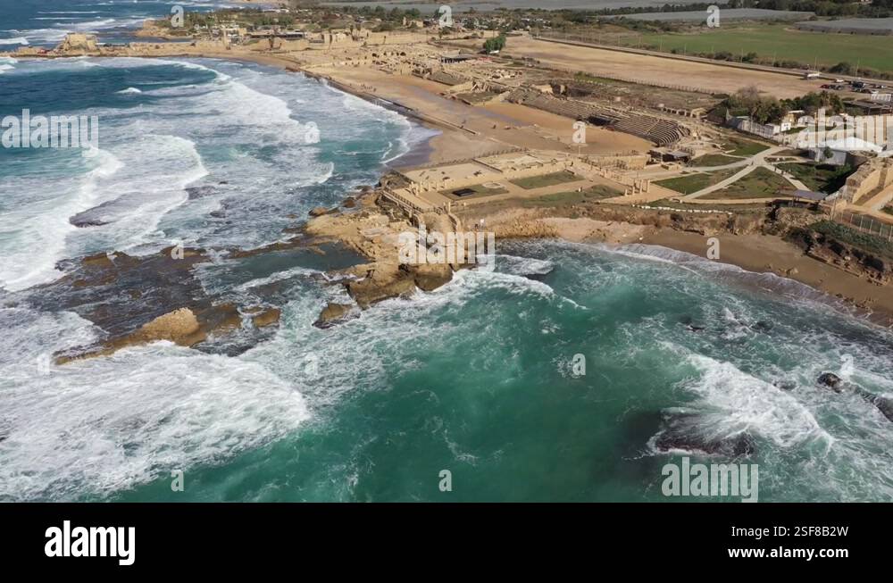 Tilting aerial view of ancient Caesarea city, spectacular shoreline in ...