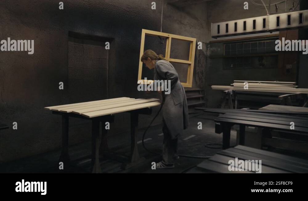 Female Worker is cleaning the wooden window parts using in the ...