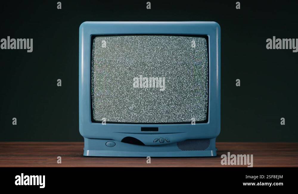 Old television with grey interference screen on black background. Close ...