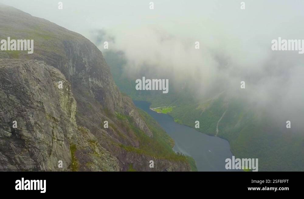 Two people on the edge of a 1000m cliff on the Norwegian Fjords that ...