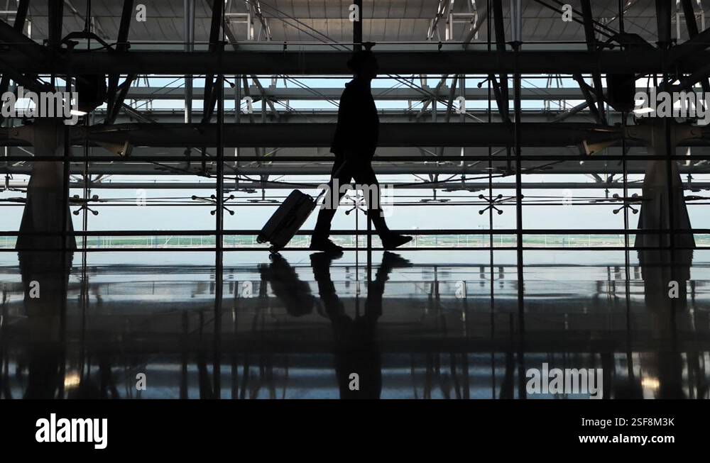 Passenger man go to boarding gate with small case, silhouetted slow ...