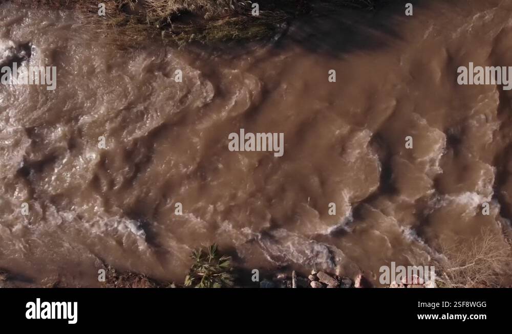 Fast flowing flooded river cascade of muddy water after powerful ...
