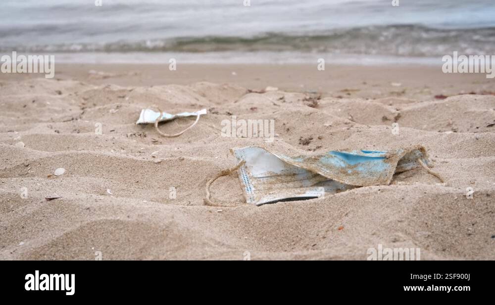 Ecological problems with masks. A view of medical blue mask in the sand ...