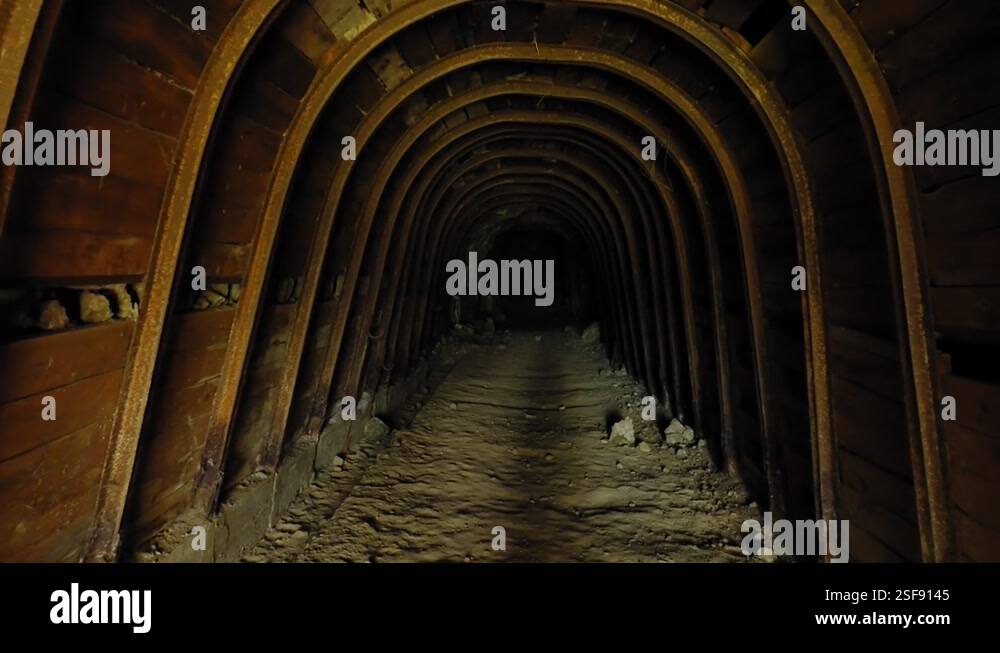 Point of view of traveling down an old mining tunnel with a shadow on ...