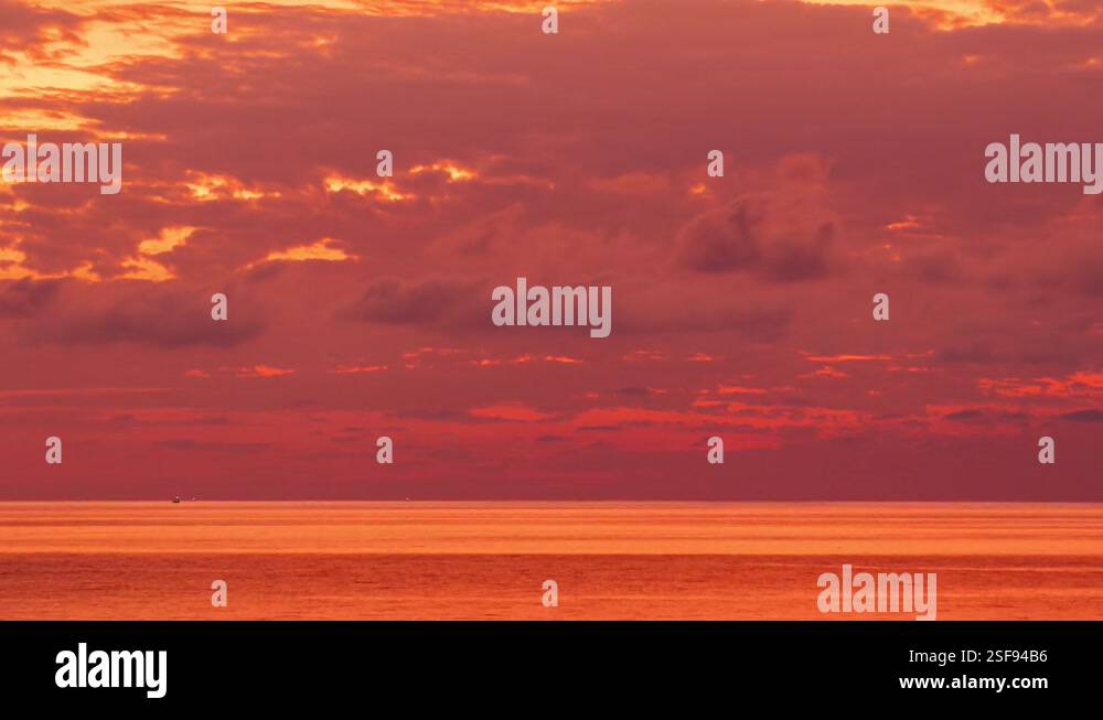 Colorful clouds in the sunrise sky over the sea. Sun rising from the ...