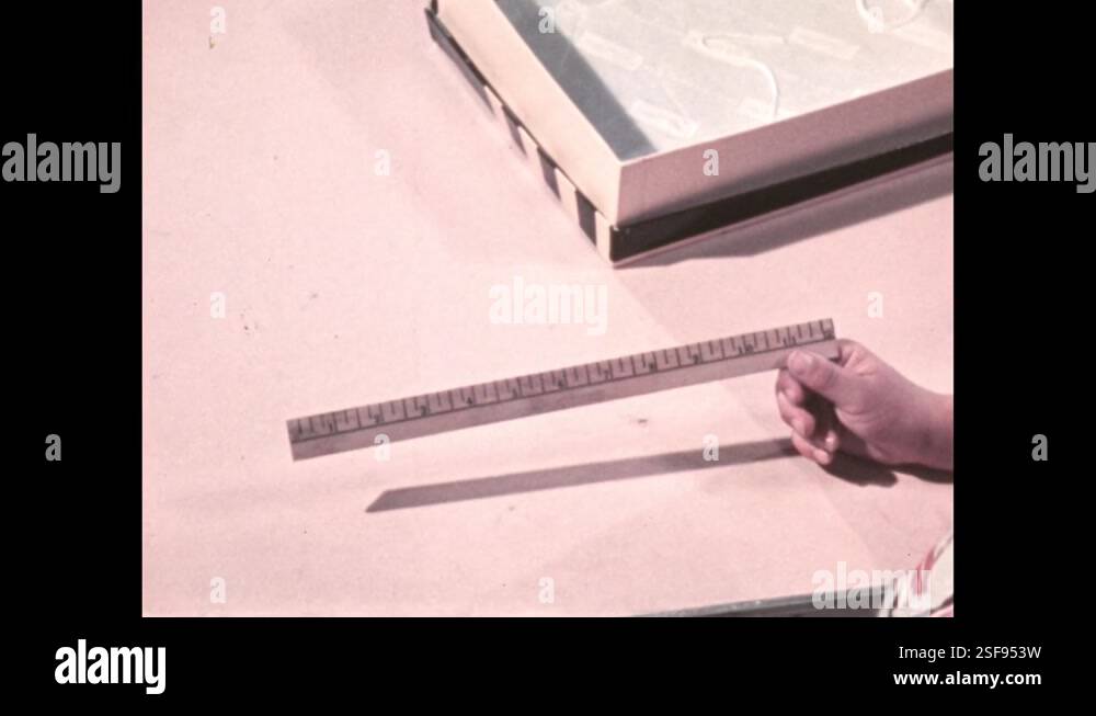 1950s: Boy holds ruler. Man places ruler on yardstick, then moves ruler ...