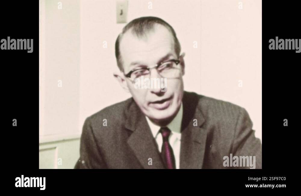 1960s: Man talking, gesturing with baton. Man sitting with books ...