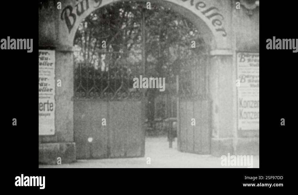 1930s: Adolf Hitler leaning out of window. Man in window. Open gate ...