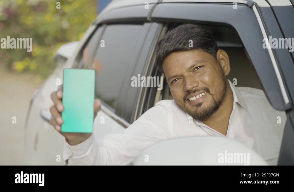 Happy cab driver showing mobile phone with green screen mockup by ...