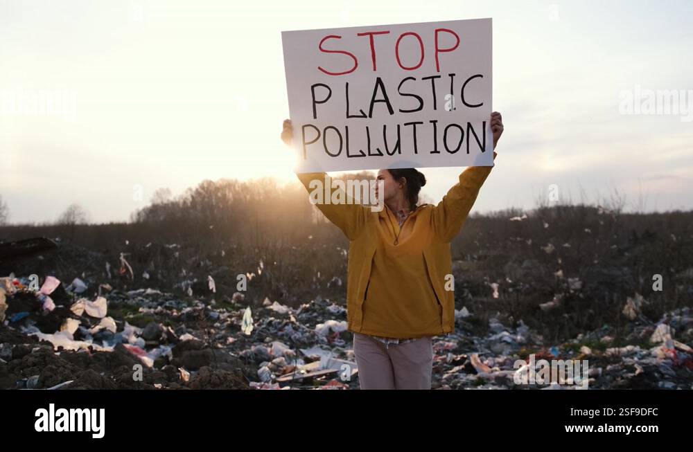 Portrait of a young European girl in a huge garbage dump with posters ...
