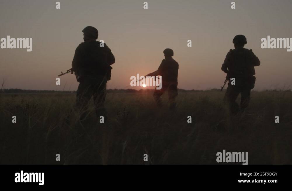 Squad of sniper soldiers with rifles aiming at target at field on ...