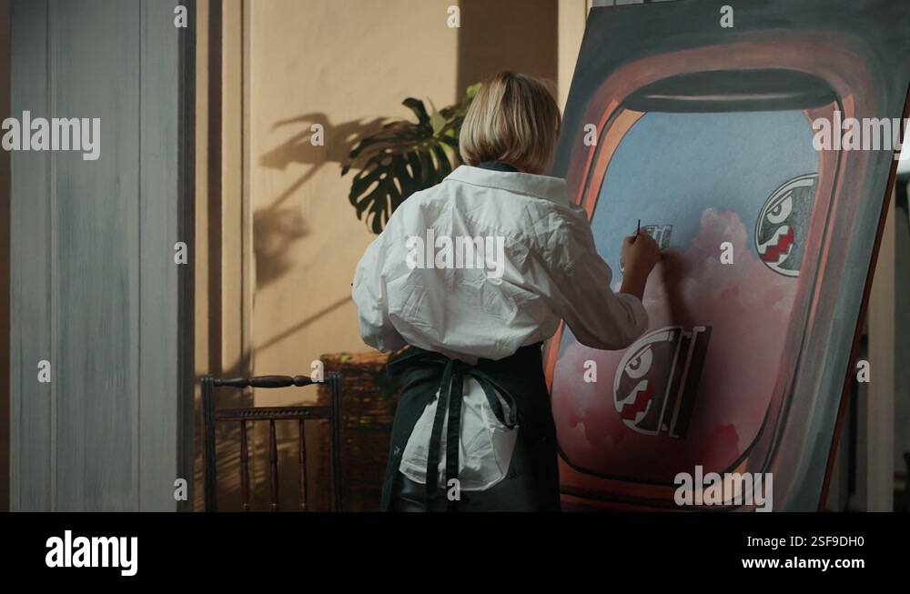 Back view of young unrecognizable woman artist creating picture at ...