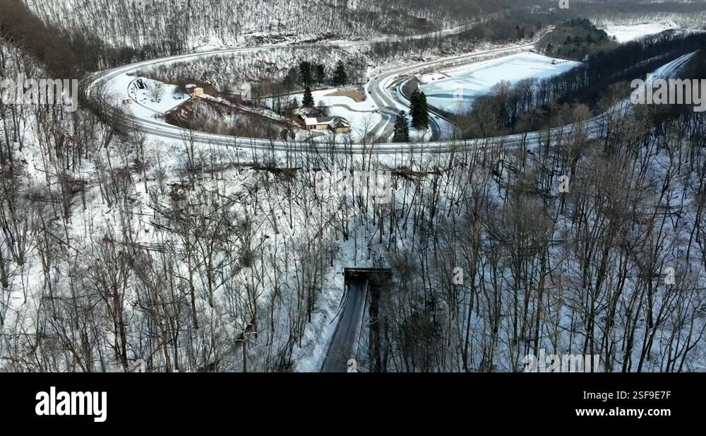 Horseshoe curve train through mountain pass. Aerial tilt up reveals ...