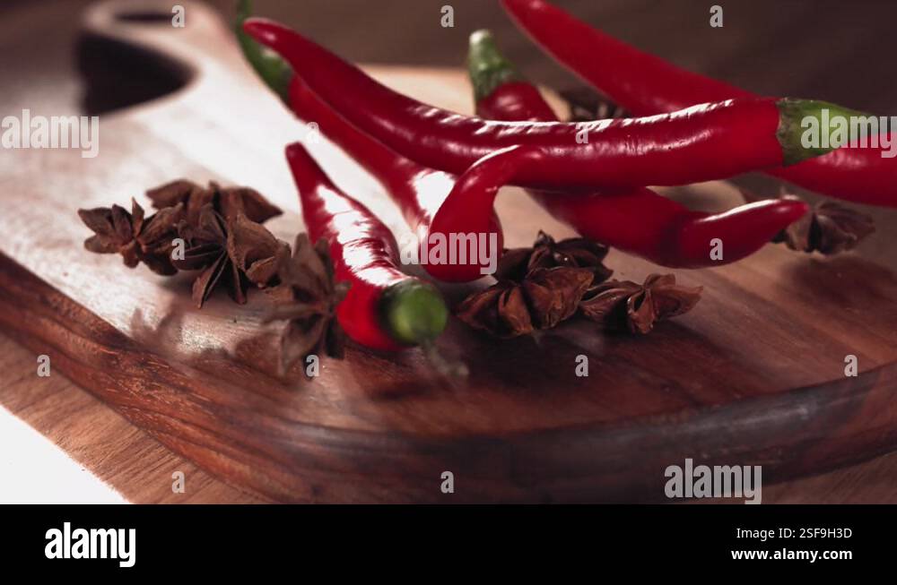 Red Chilli Pepper and Anise falling down on wood. Slow Motion Stock ...