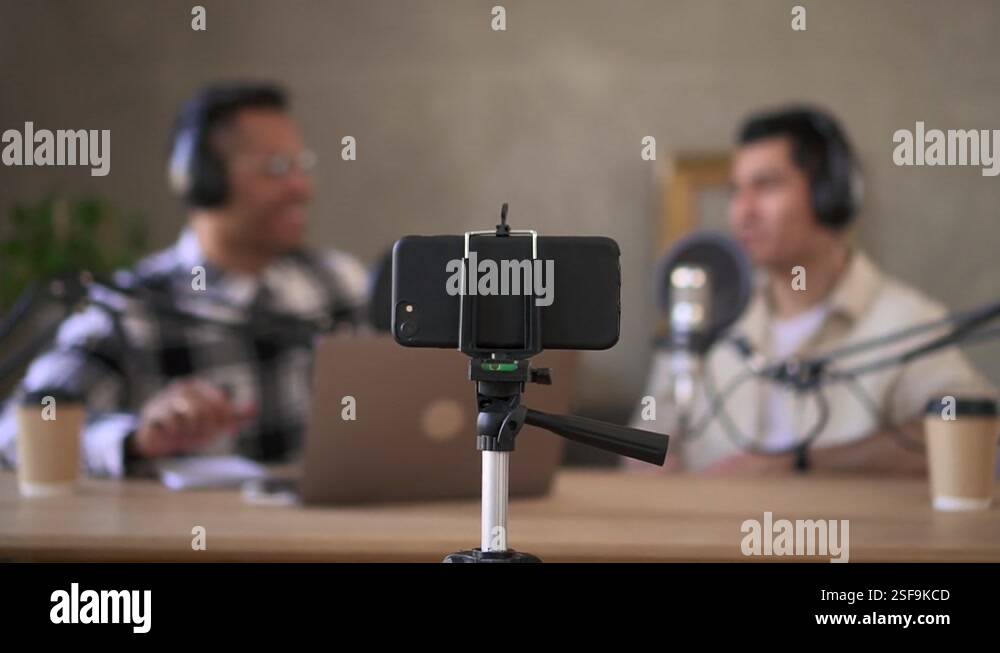 Man recording podcast on phone camera, shooting filming video in home ...