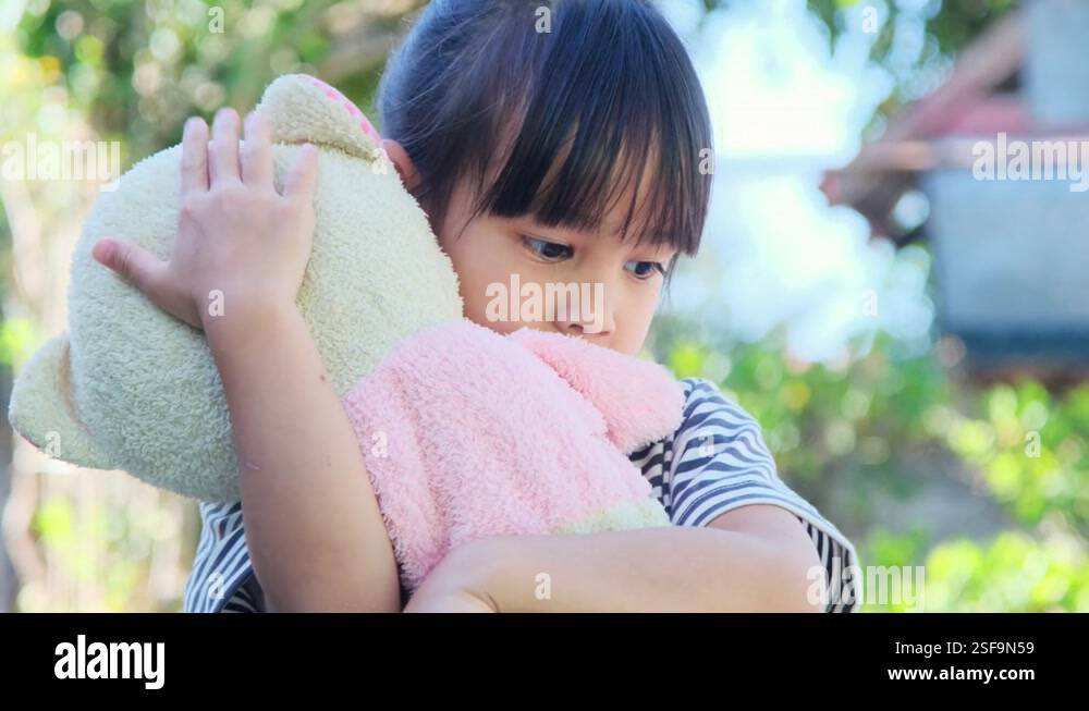 Cute little girl embracing her doll in the front yard Stock Video ...