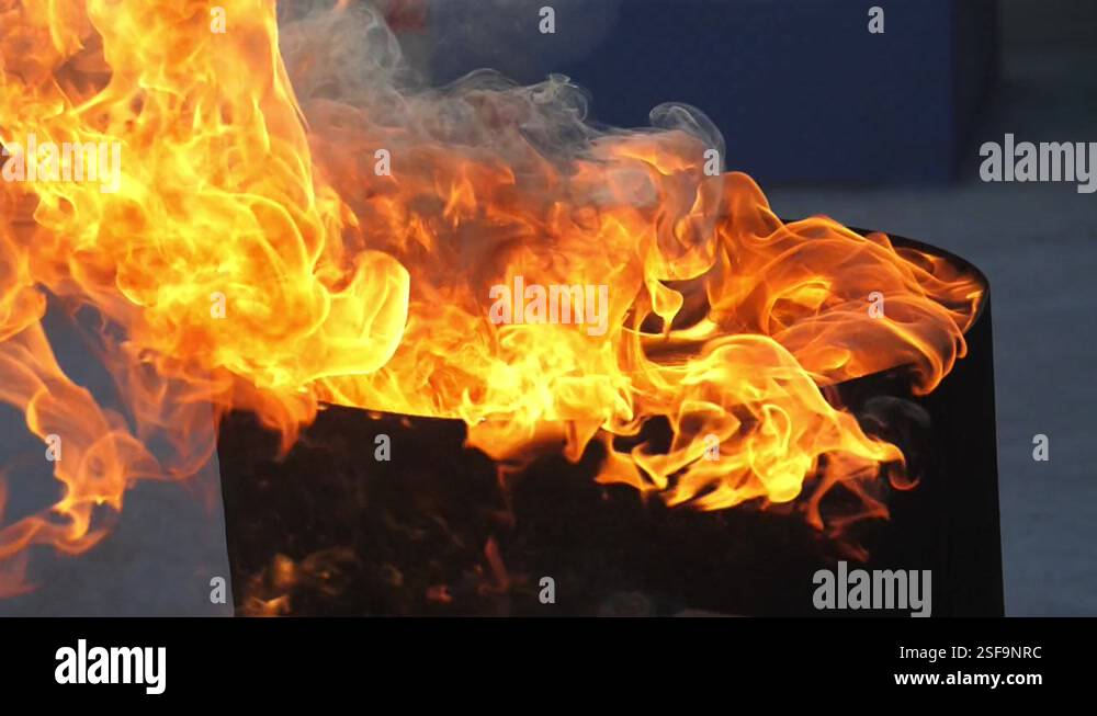 A fireman sets fire to a barrel of fire, close-up, slow motion Stock ...