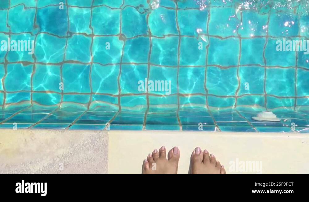 Woman feet on Crystal clear blue swimming pool water with wave n ripple ...