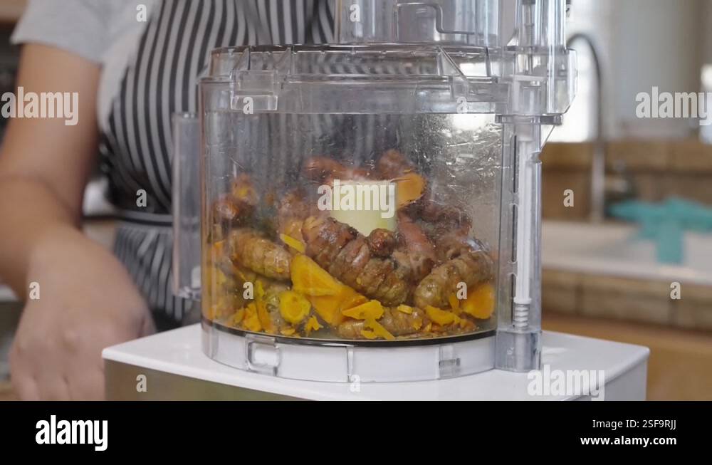 Grinding turmeric in a food processor to make a traditional tincture ...