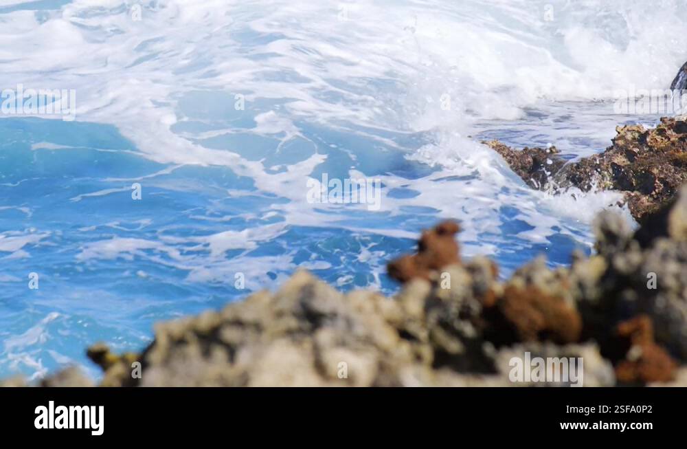 Ocean waves swelling and crashing onto the rocky shore in Curacao Stock ...