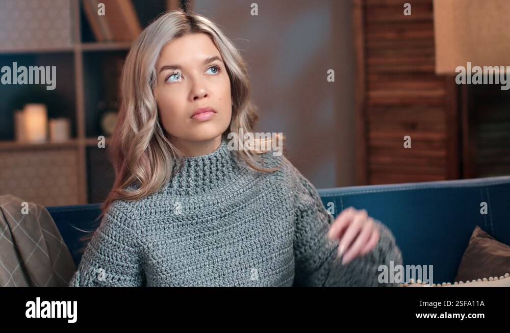 Blonde woman in warm sweater reading book tired feeling stress headache ...