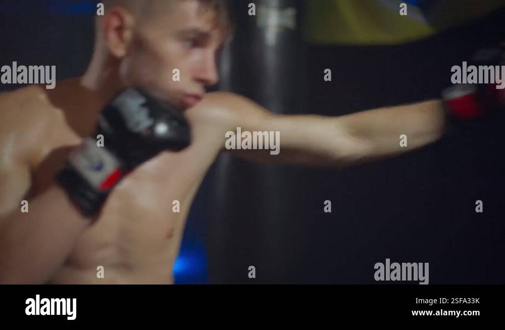 A boxer makes a series of punches on a punching bag using his arms and ...