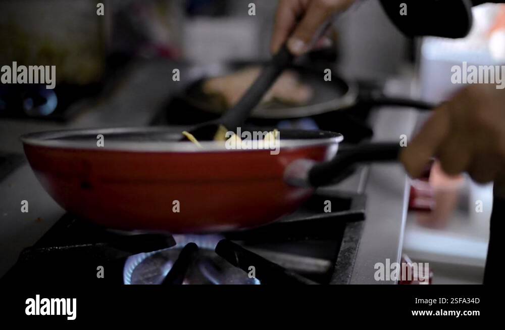 Chef sou-chef preparing a traditional mexican dish called chilaquiles ...