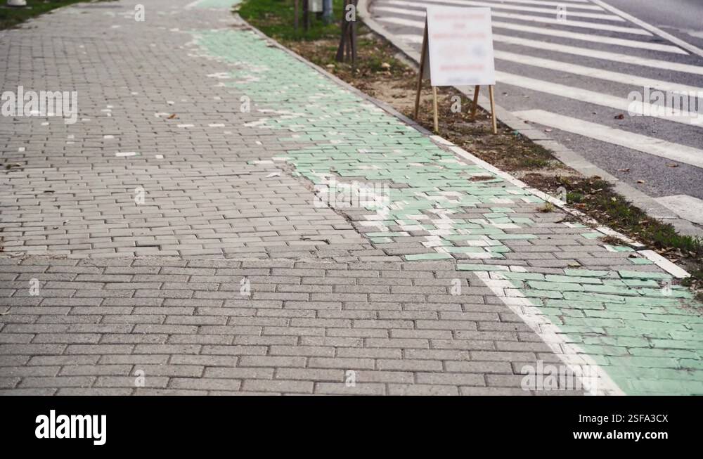 Renovated gray and green sidewalk and bike path. Poorly placed stones ...